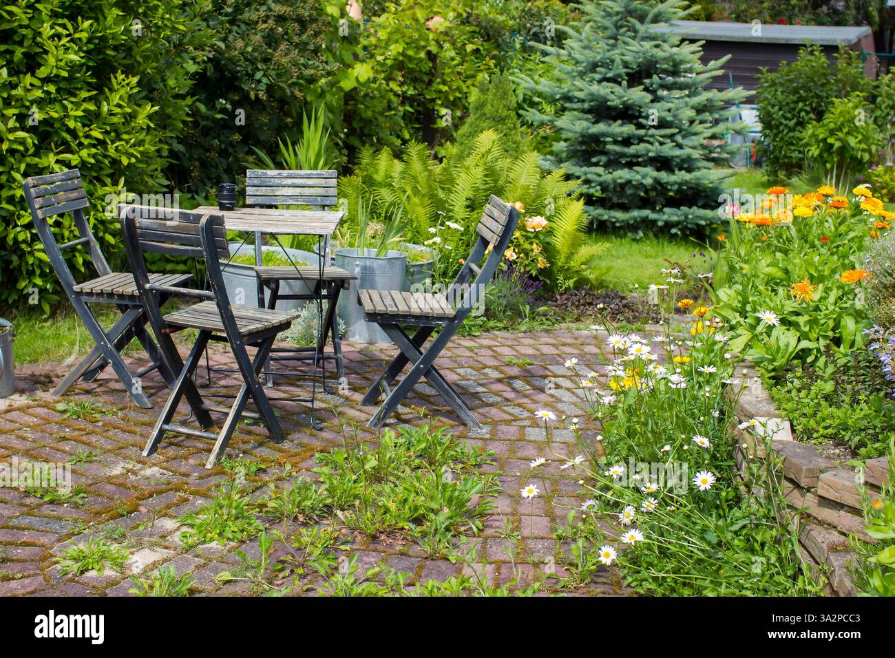 erb spiral in the garden and table with chairs Stock Photo - Alamy