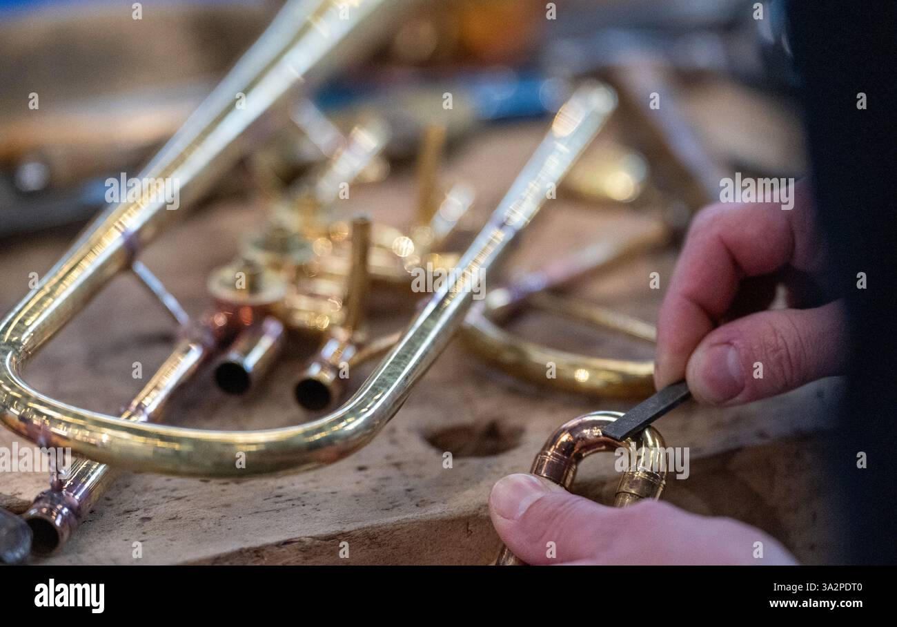 Munich, Germany. 13th Mar, 2025. A metal wind instrument maker works on ...