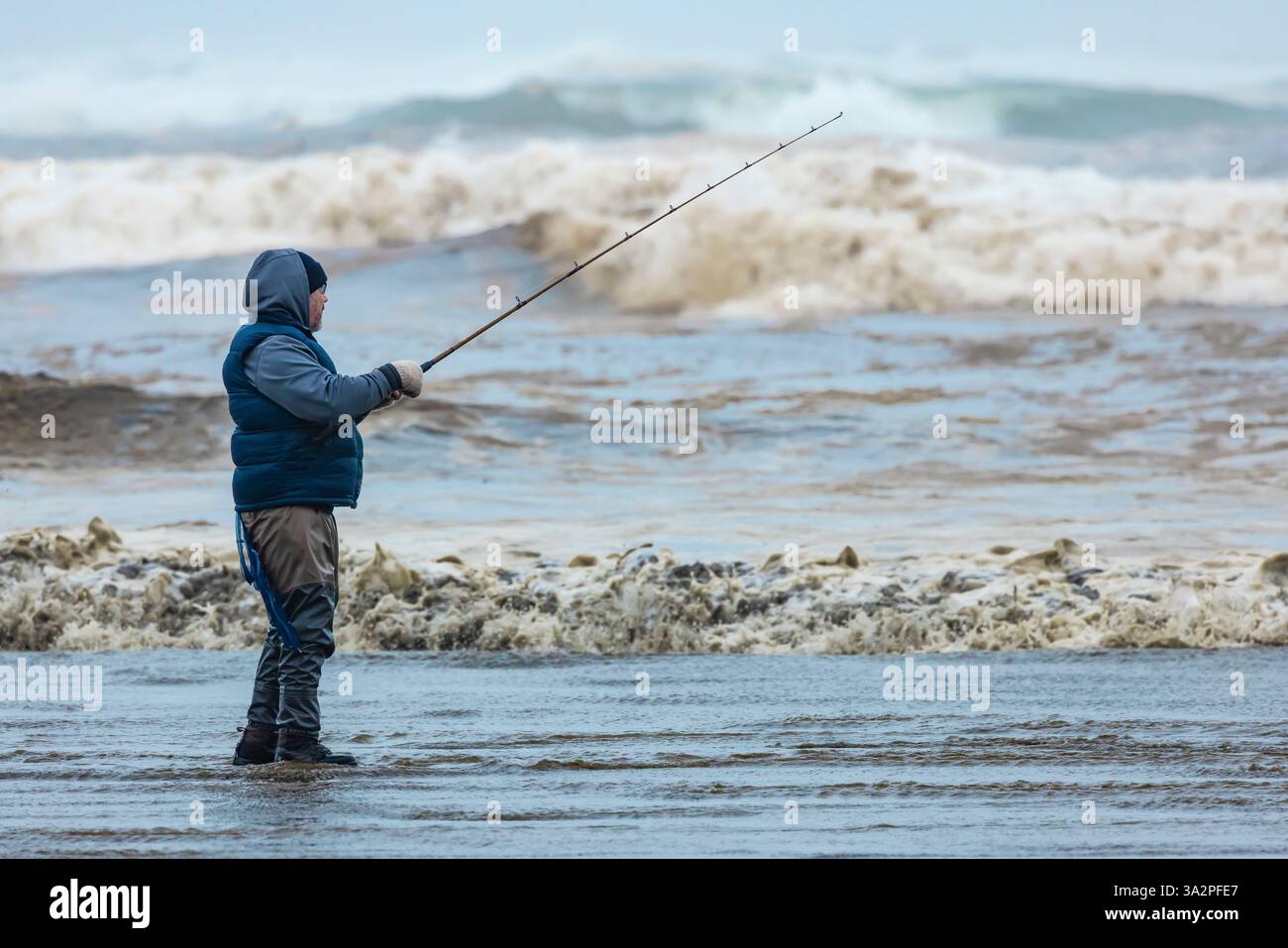 Surf fisherman casting into the waves of the Pacific Ocean at Ocean ...