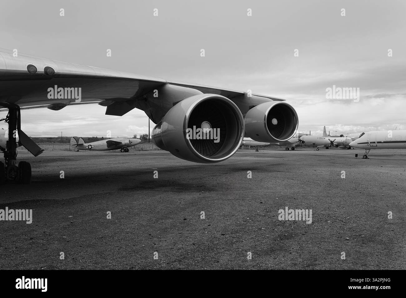Monochrome image highlighting massive jet engines beneath an aircraft ...