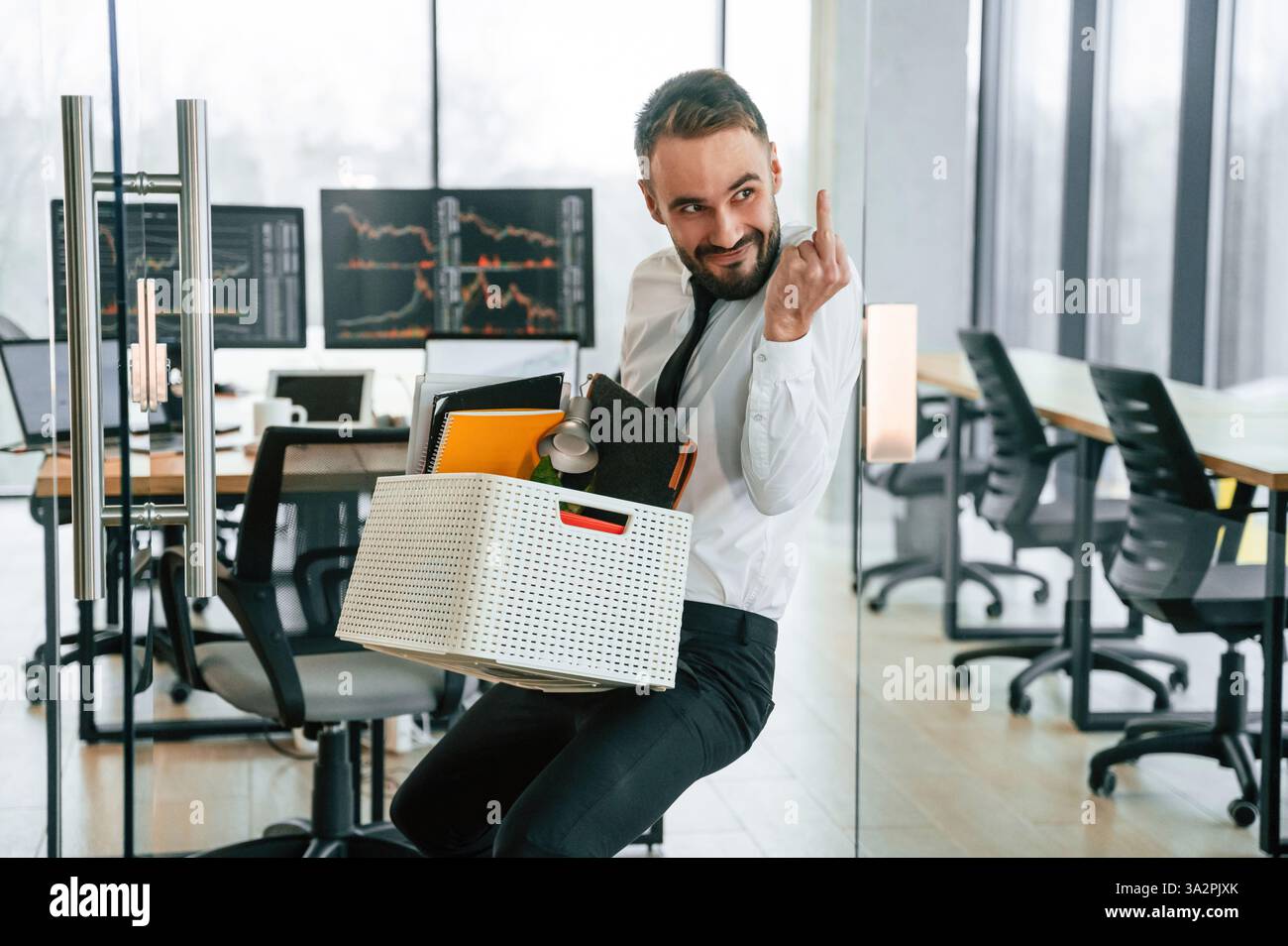 Showing middle finger. Unemployed man is with personal belongings after ...