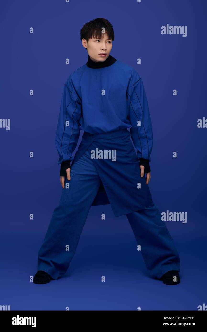 Handsome young Asian man poses confidently in an artistic blue outfit ...
