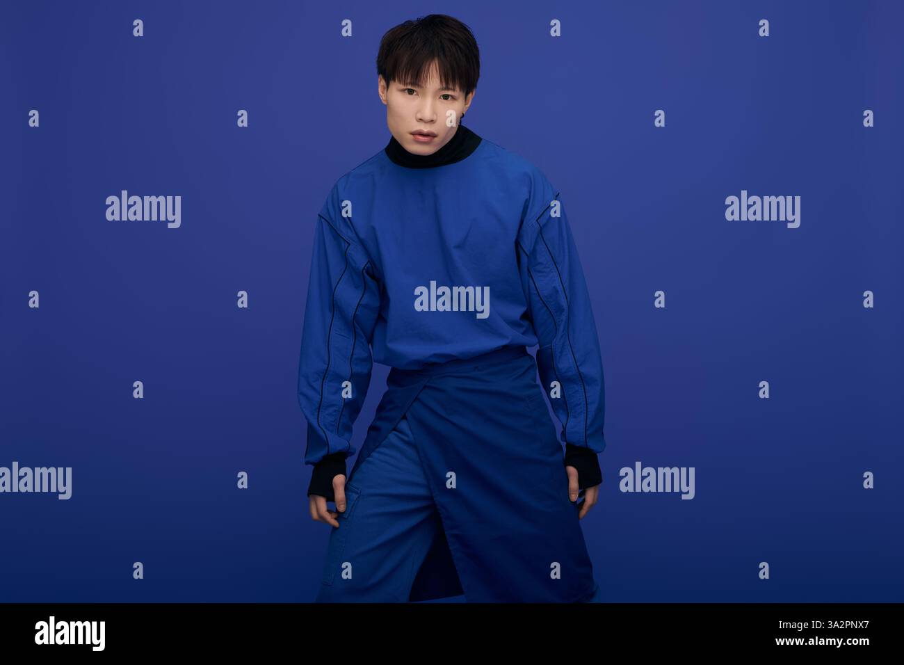 A young attractive Asian man showcases modern fashion, striking a bold ...