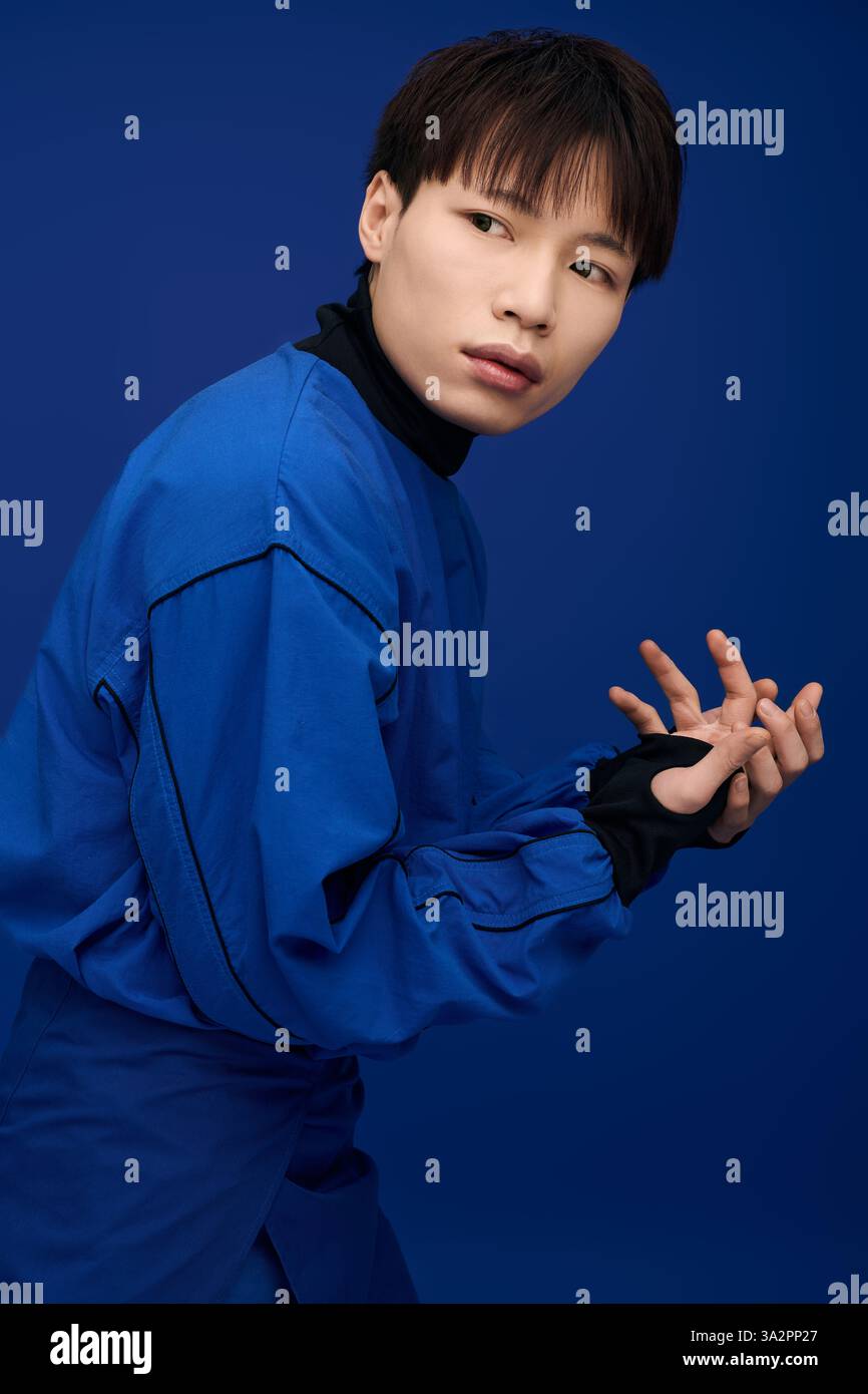 A young attractive Asian man showcases his unique style in a bold blue ...