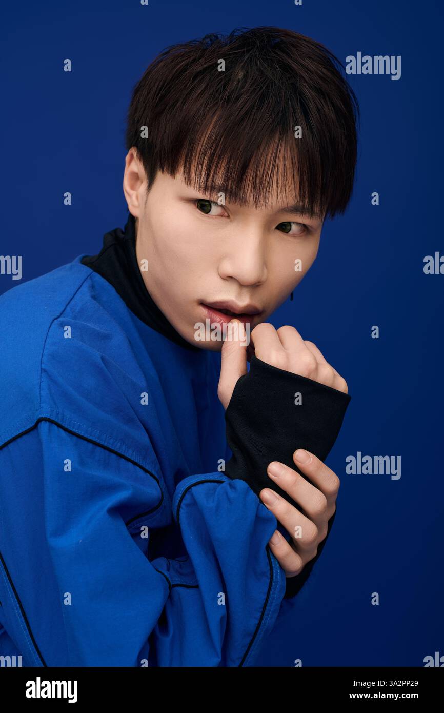 A handsome young Asian man with striking features wears stylish blue ...