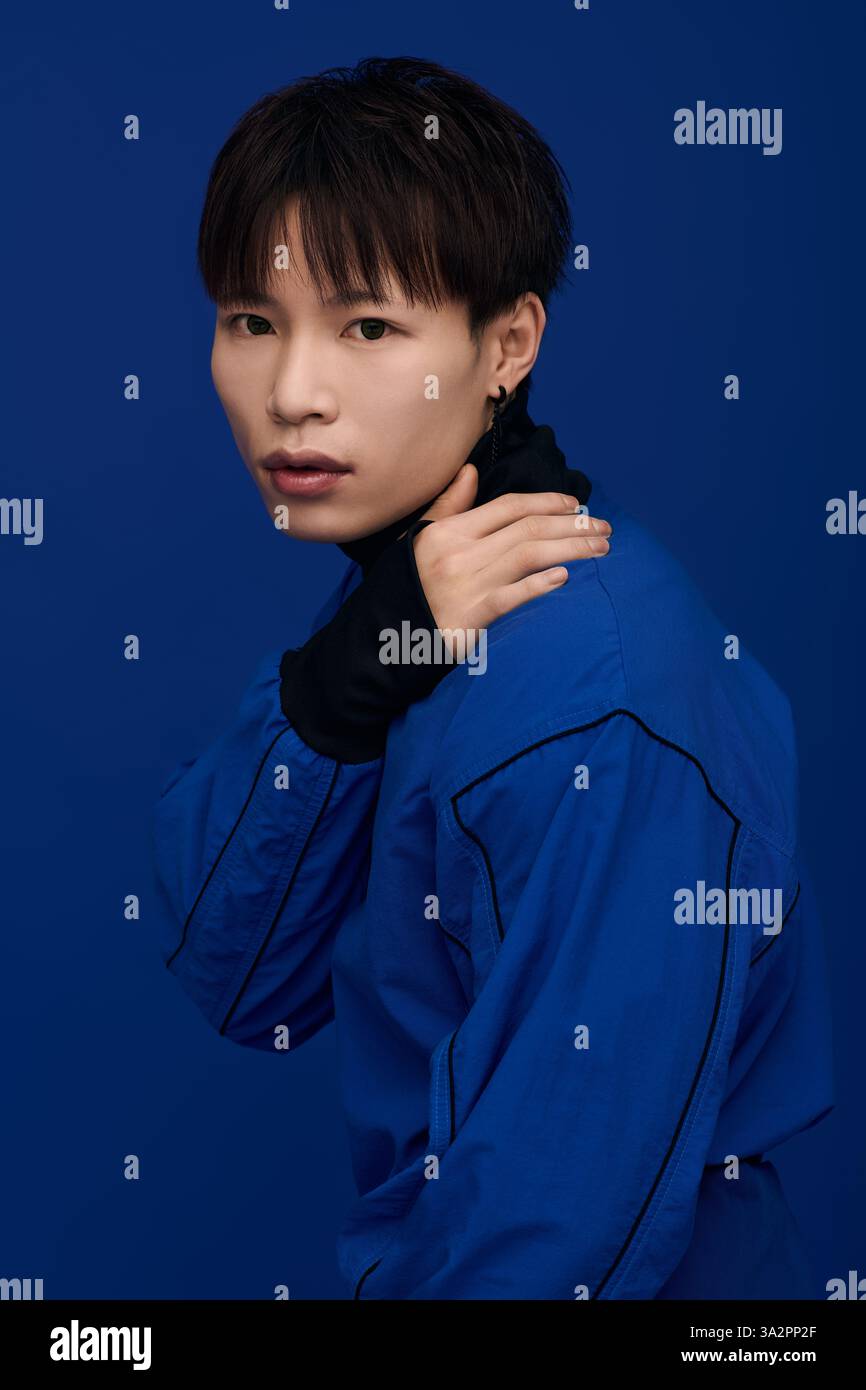 Confident young Asian man showcases style and charisma in a modern ...