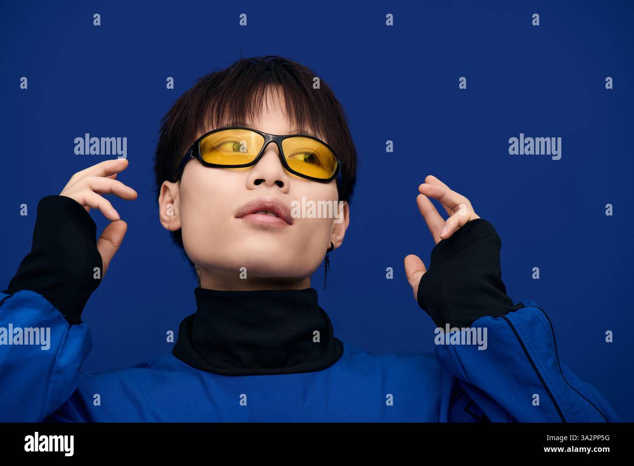 Attractive young asian man showcases trendy sunglasses while striking a ...