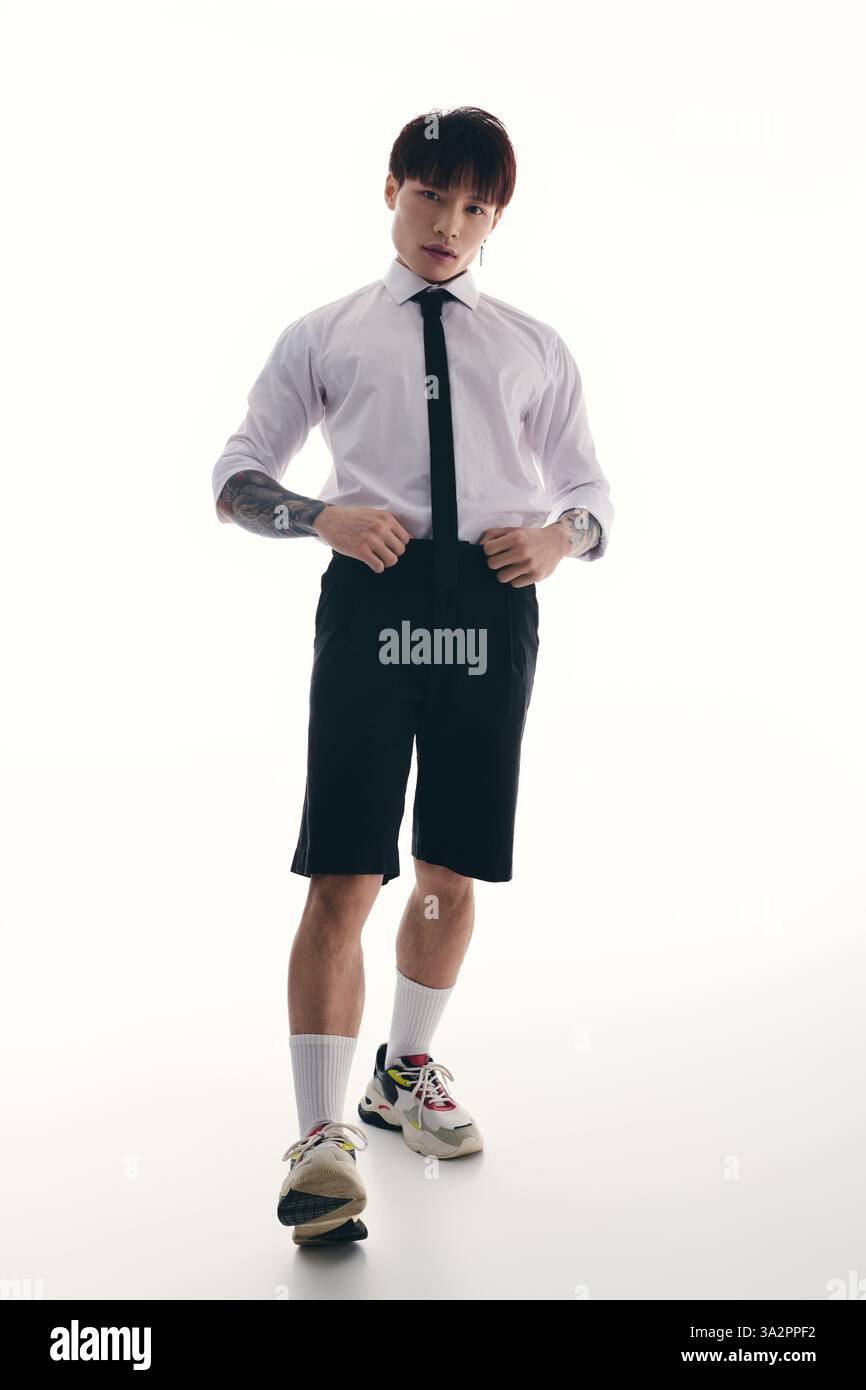 A handsome young asian man stands confidently, showcasing a trendy ...