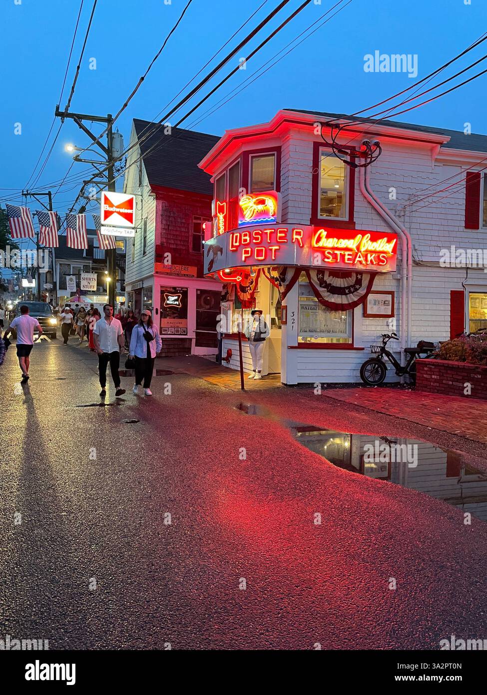 Following a summer rain, people walk in Provincetown, Massachusetts, on ...