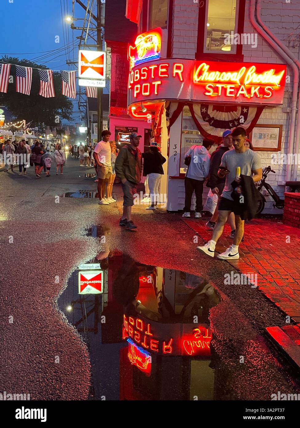 The lights of the bright neon sign for the Lobster Pot is reflected in ...