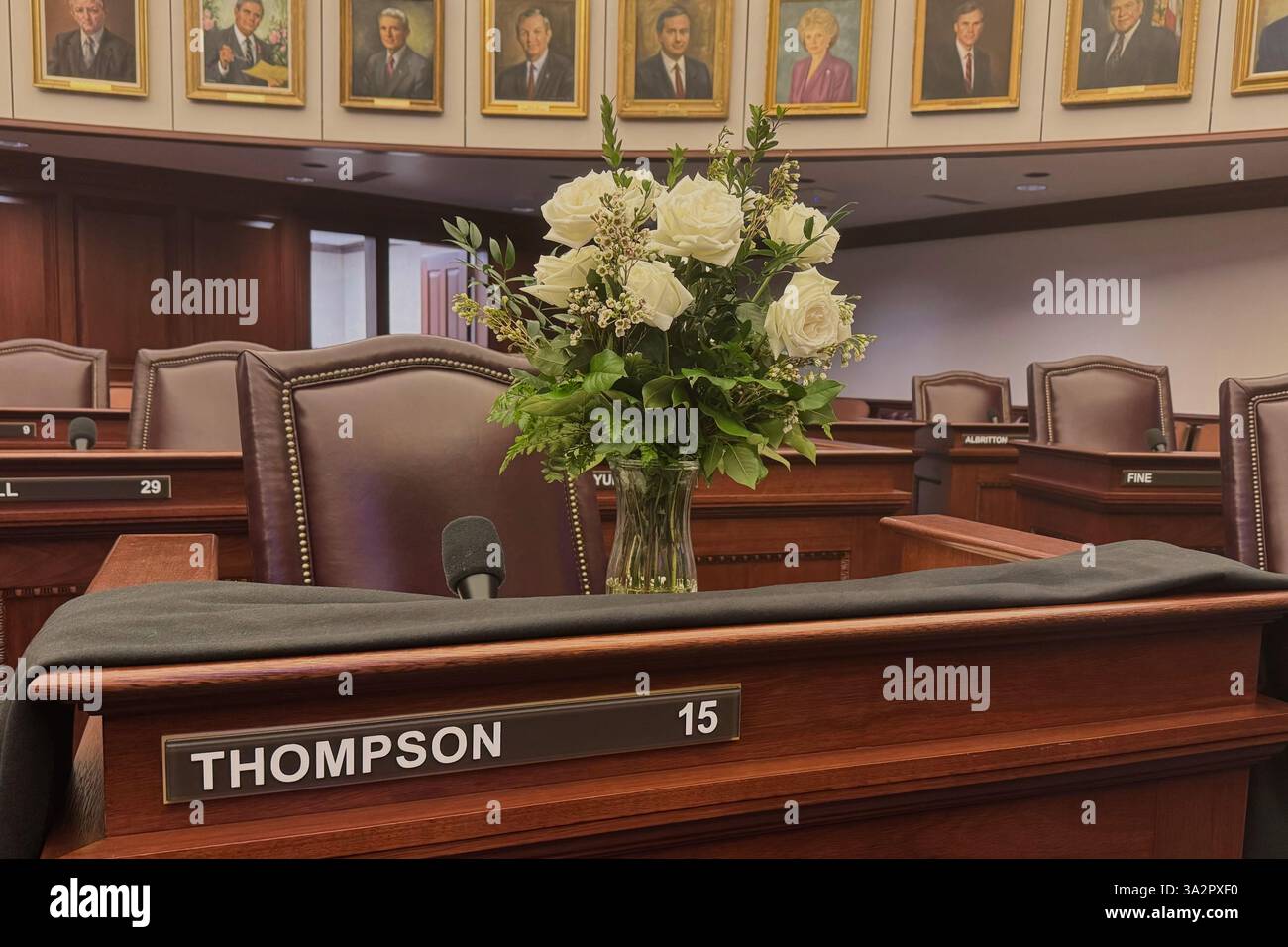 A bouquet of flowers and a black cloth adorn the desk of the late ...