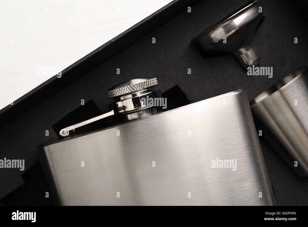 Hip flask, cup and funnel in package on white table, top view Stock ...