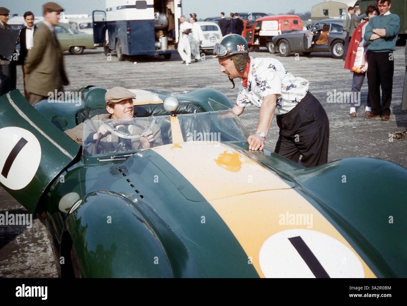1960s, historical, motor sport, in a back area of a motorsport event, a ...