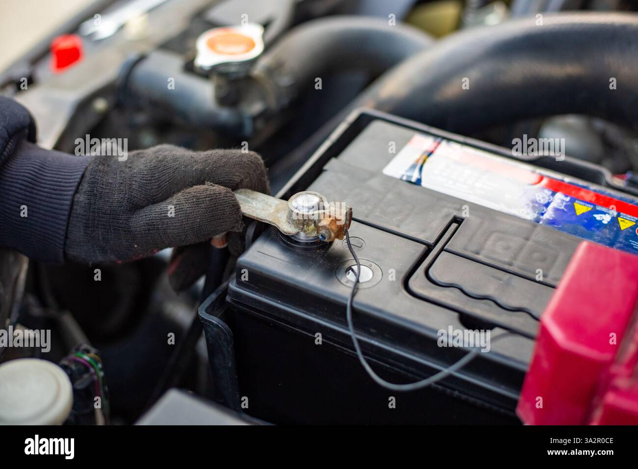 Replacing a car battery. A man installs a battery by putting terminals ...