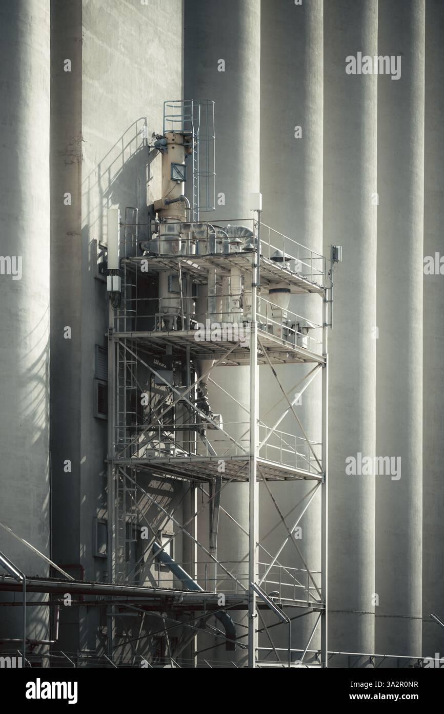 Industrial grain elevator with large cylindrical silos, metal platforms ...