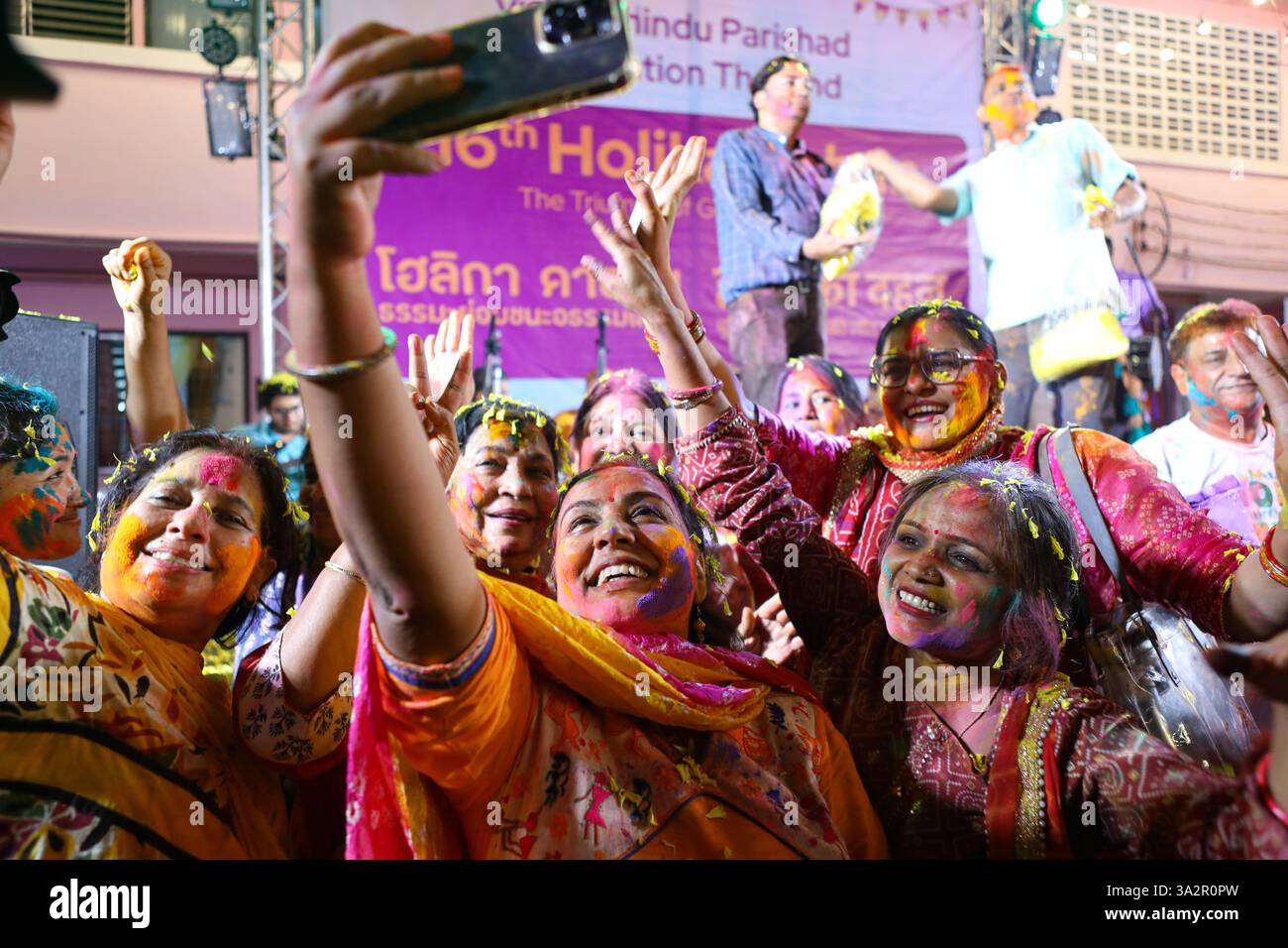 Bangkok, Thailand. 13th Mar, 2025. People dance and throw brightly ...