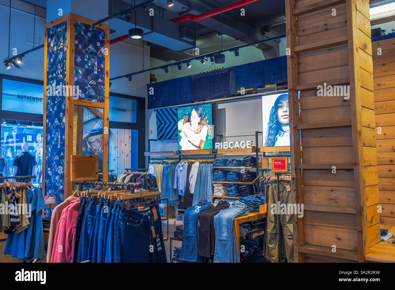 Interior of Levi's store with denim jeans, wooden shelves, digital ...