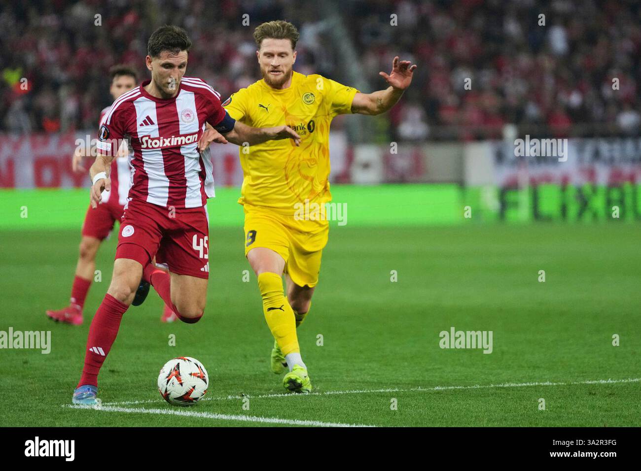 Olympiacos' Panagiotis Retsos, left, and Glimt's Kasper Hogh vie for ...