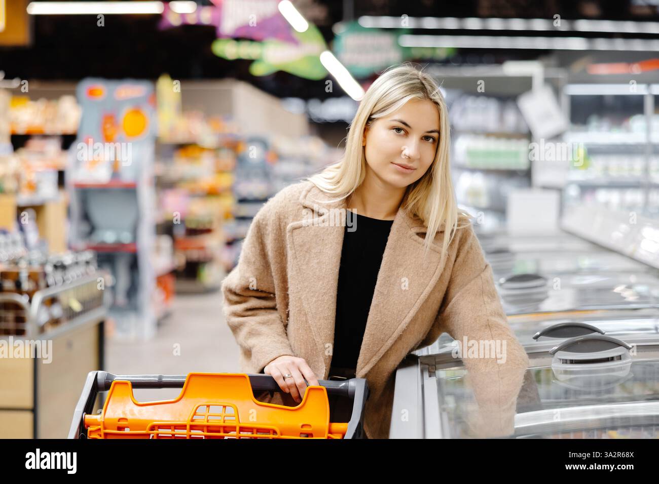 Blonde woman shopping groceries opening freezer in supermarket ...