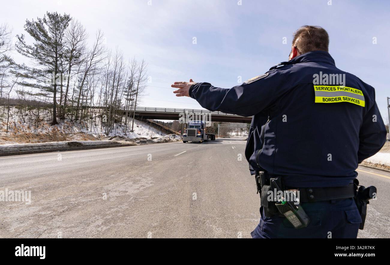 A Canada Border Services officer directs a truck carrying lumber as it ...