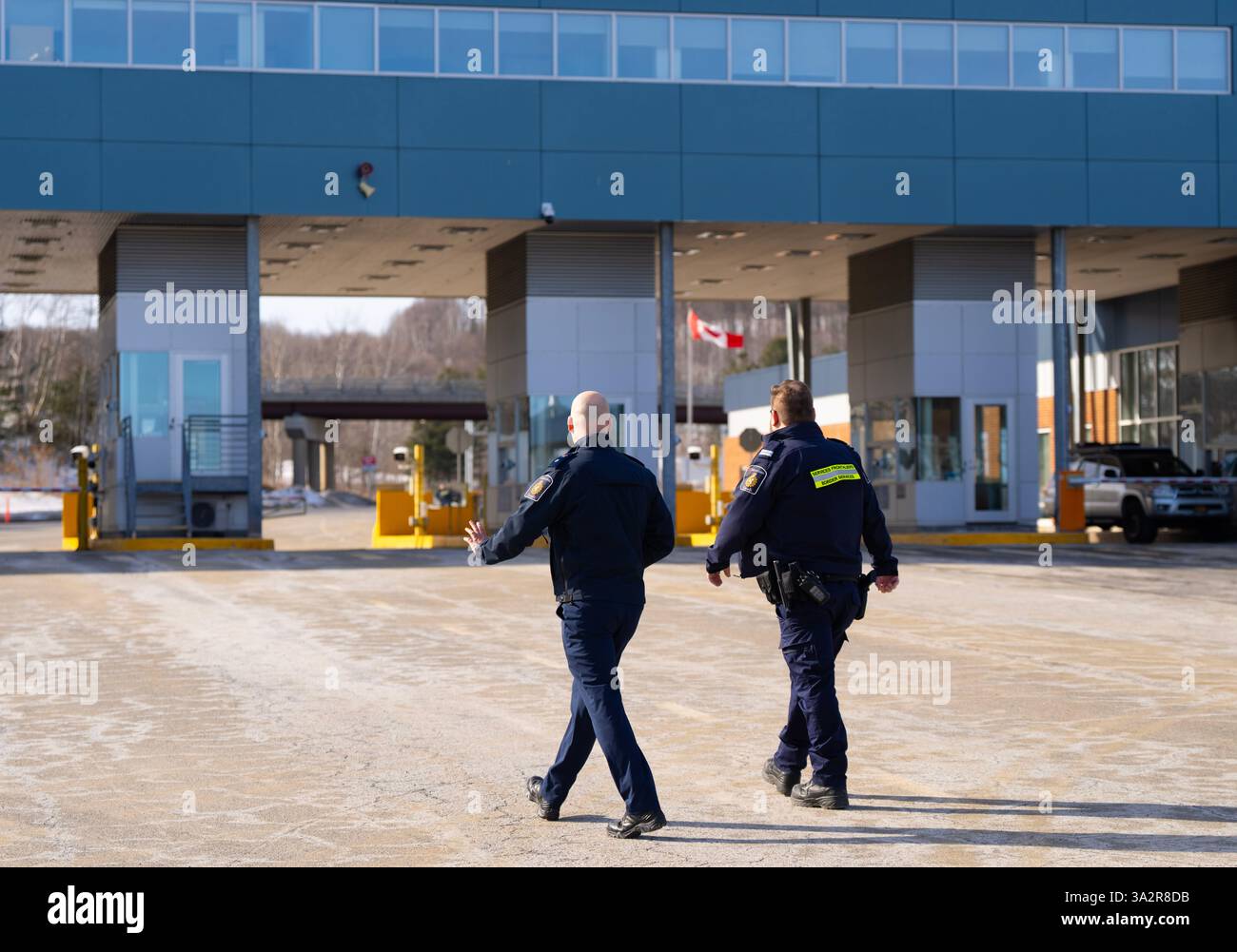 Canada Border Services officers walk past customs booths at the Highway ...