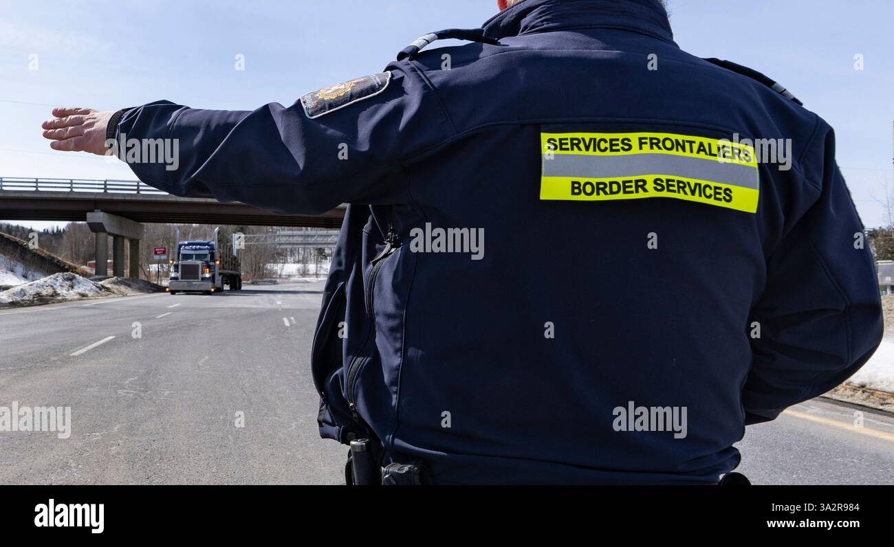 A Canada Border Services officer directs a truck as it approaches the ...