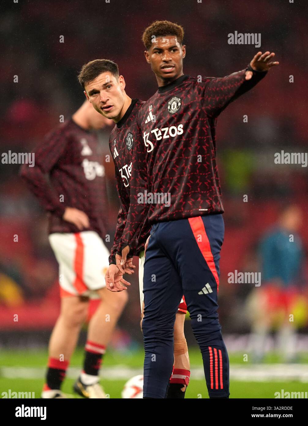 Manchester United's Manuel Ugarte (left) speaks with team-mate Marcus ...