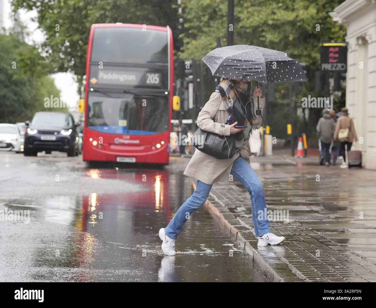 A person walks through a puddle on Euston Road in London after parts of ...