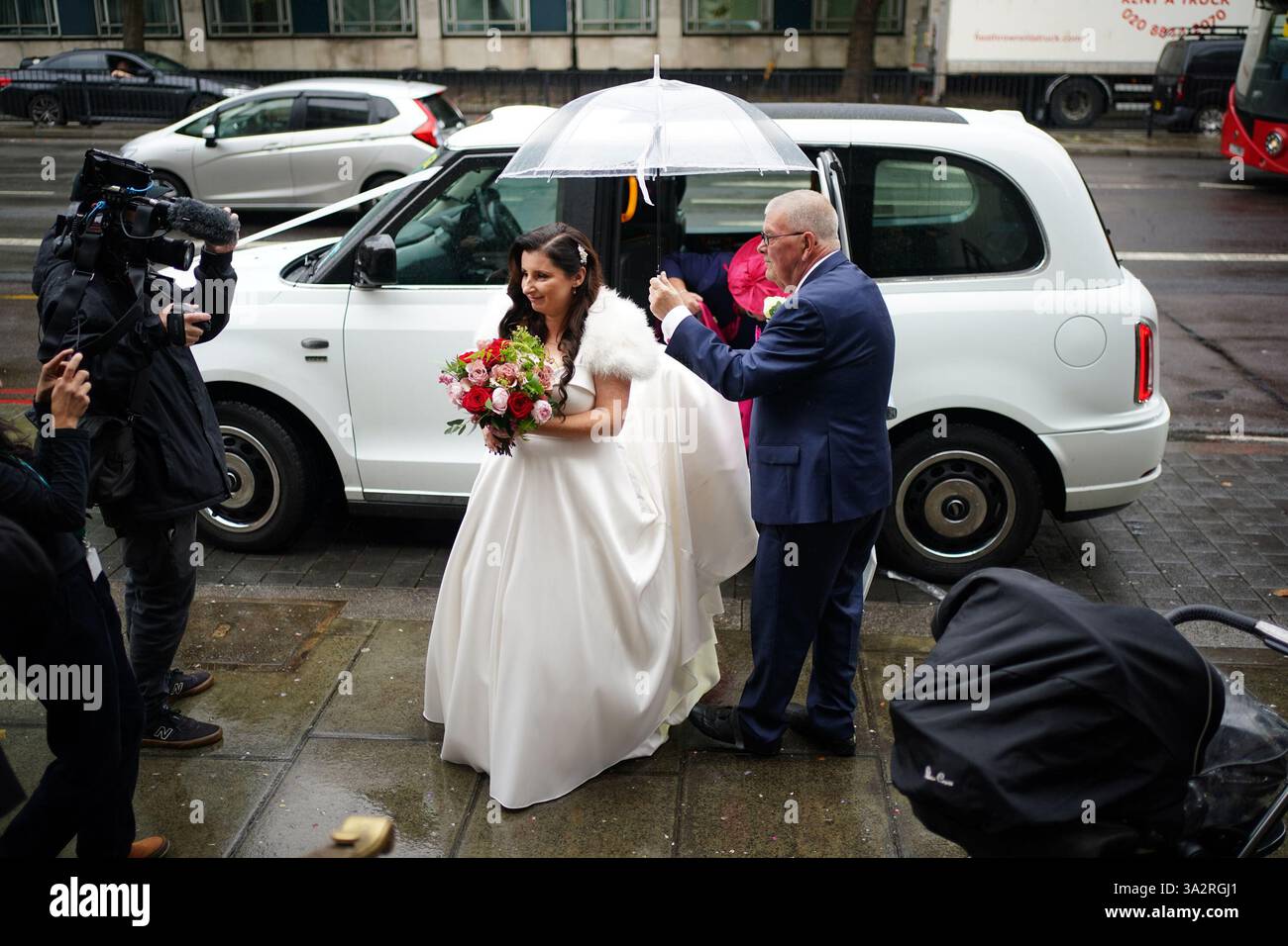 A bride arrives for her wedding at Old Marylebone Town Hall in London ...