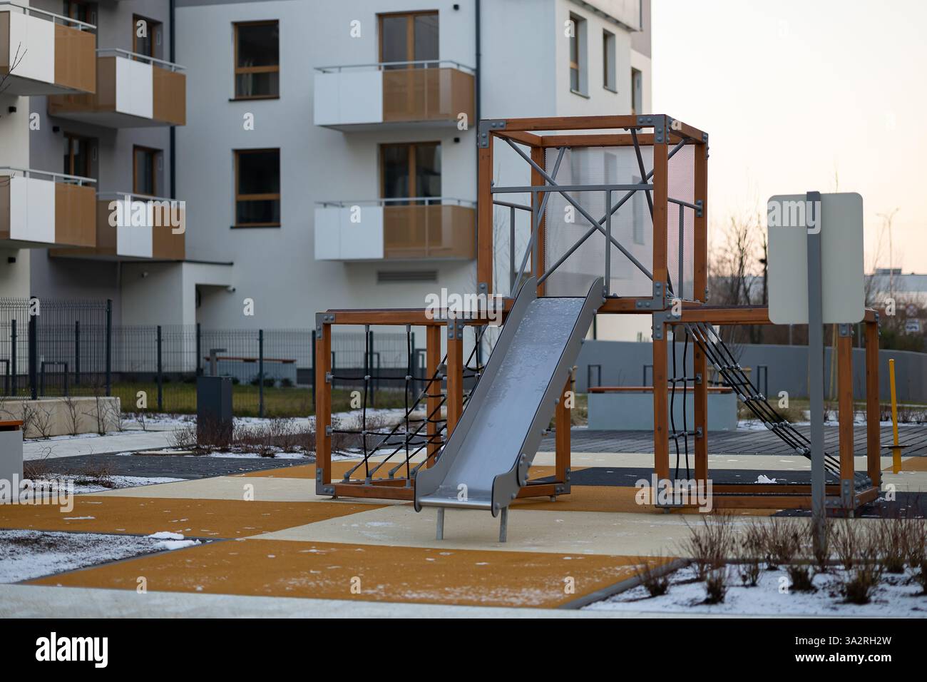 Modern playground with wooden and metal climbing structures, slide, and ...