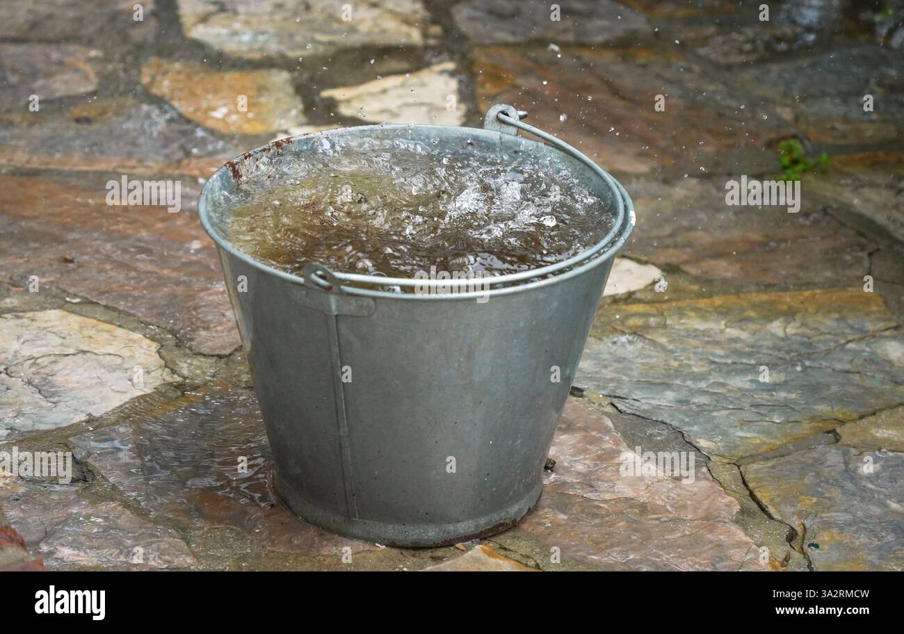 Rainwater collecting in a aluminium bucket hi-res stock photography and ...