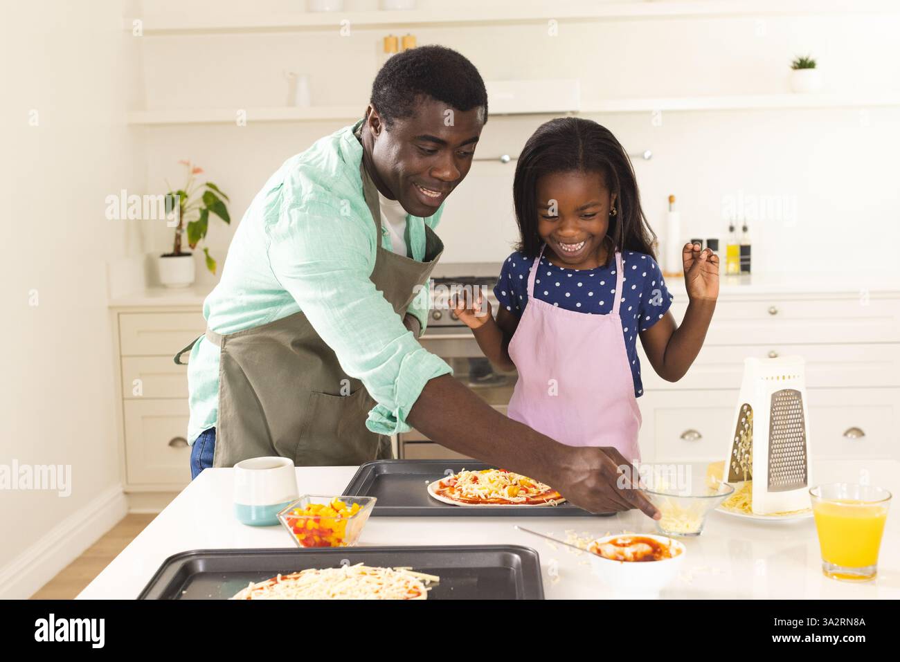 Making homemade pizza, African American father and child smiling ...