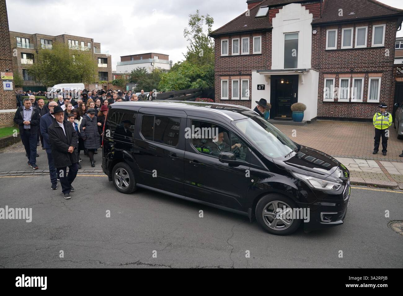 Close relatives, friends and family walk behind the funeral car ...
