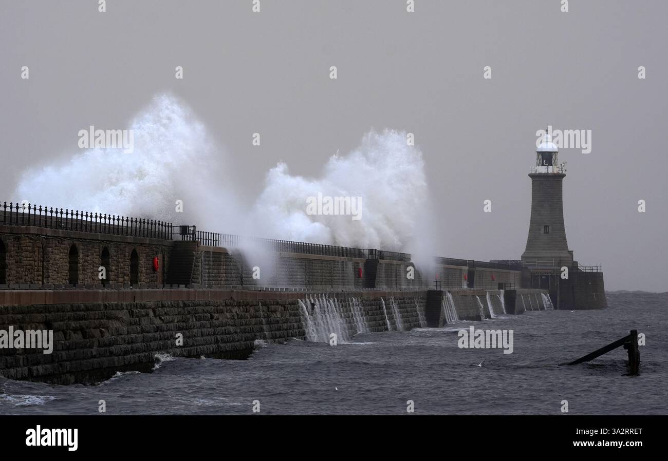 Waves crash over the Tynemouth pier lighthouse at the mouth of the ...