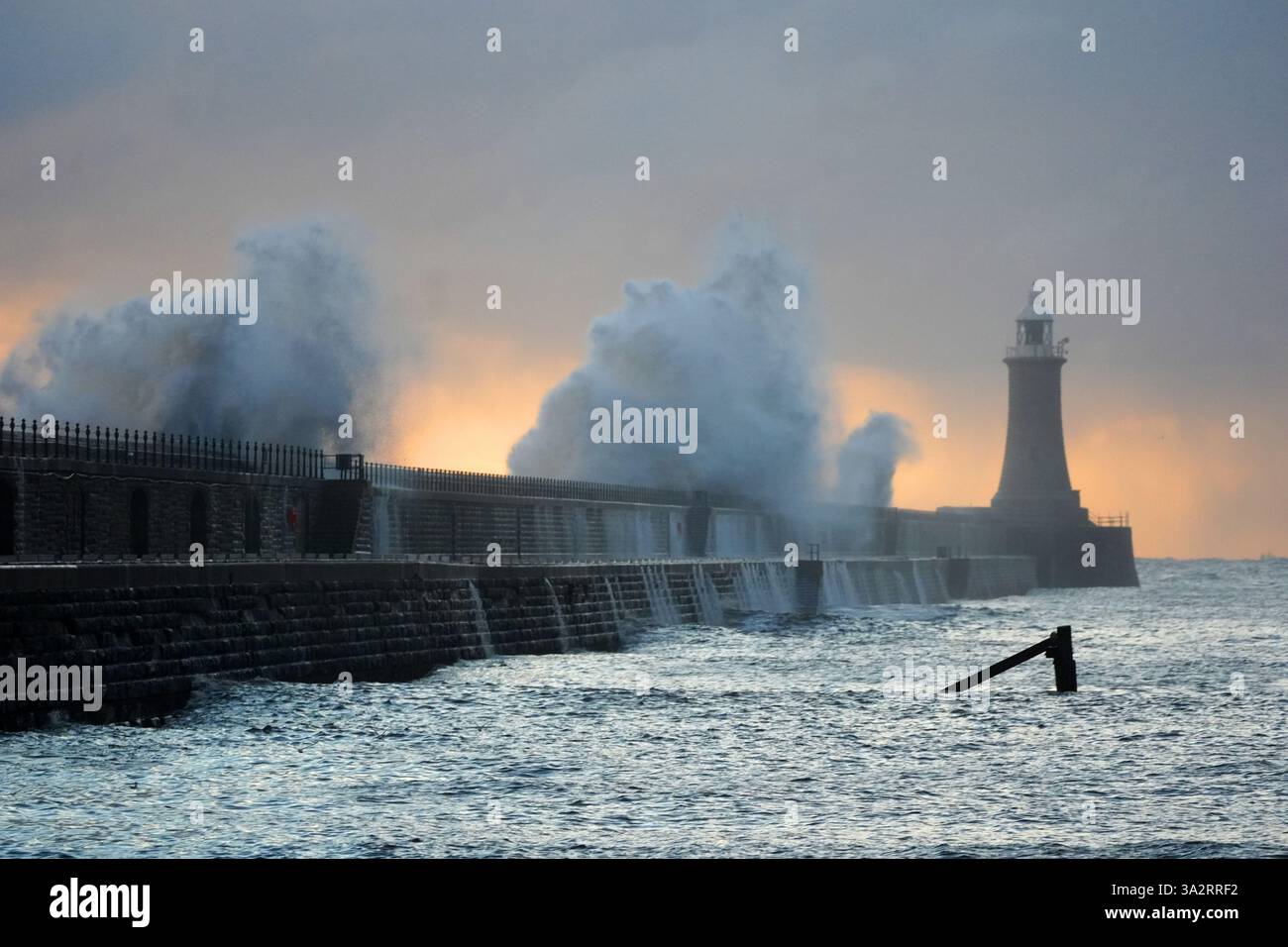 Waves crash over the Tynemouth pier lighthouse at the mouth of the ...
