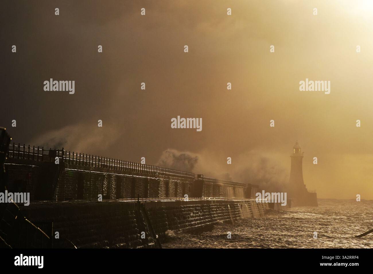 Waves crash over the Tynemouth pier lighthouse at the mouth of the ...