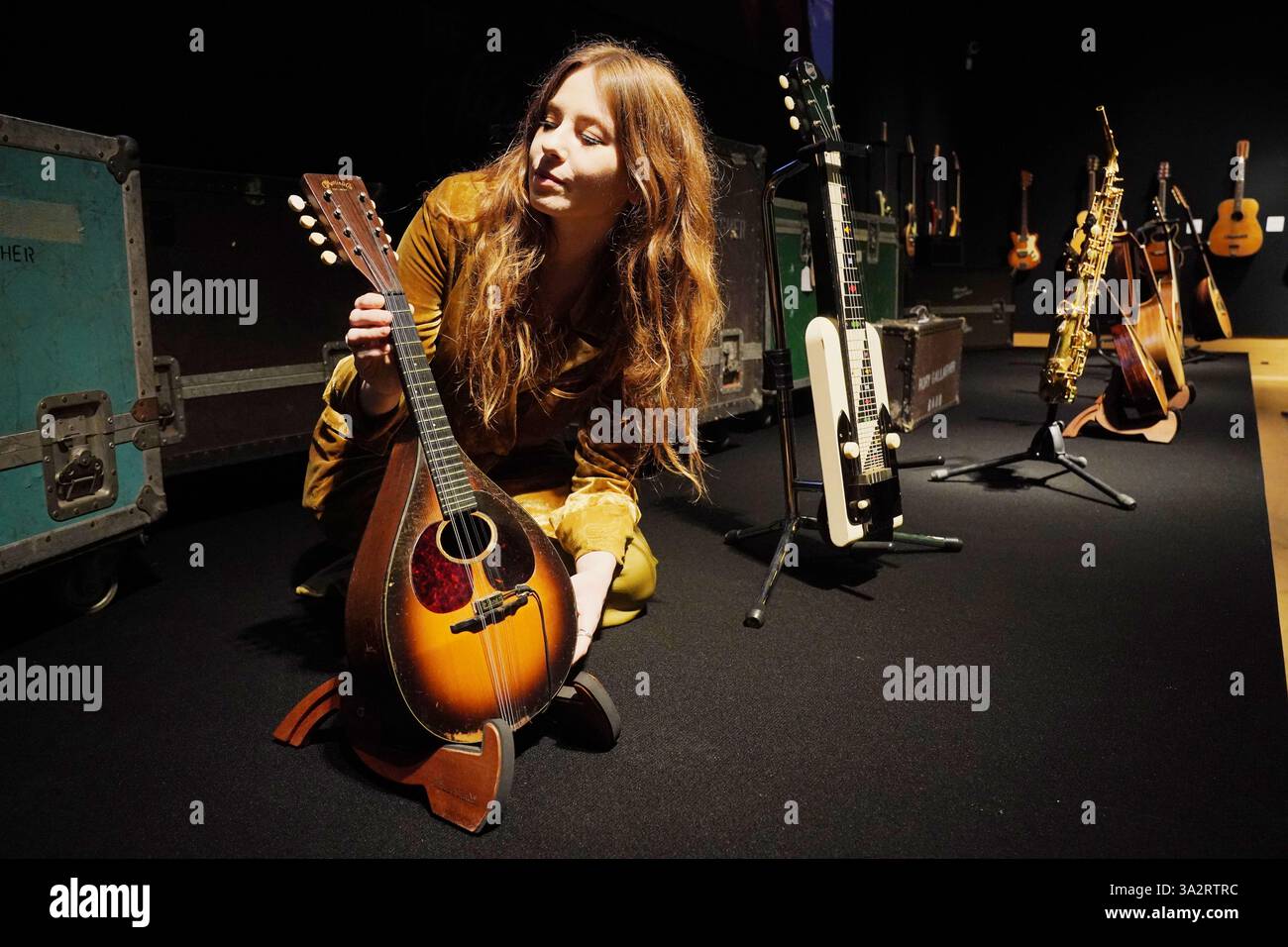 A member of Bonham's staff handles a Martin Mandolin with an Ibanez ...