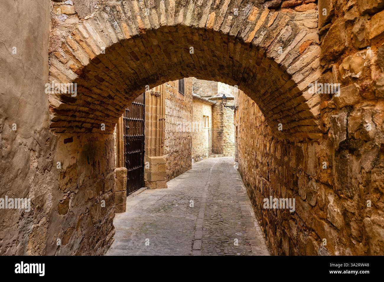 Stone arch in the picturesque narrow streets of the medieval town of ...