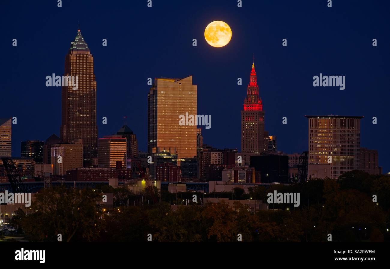 The full moon of October 17, 2024, rises above and between towers over ...