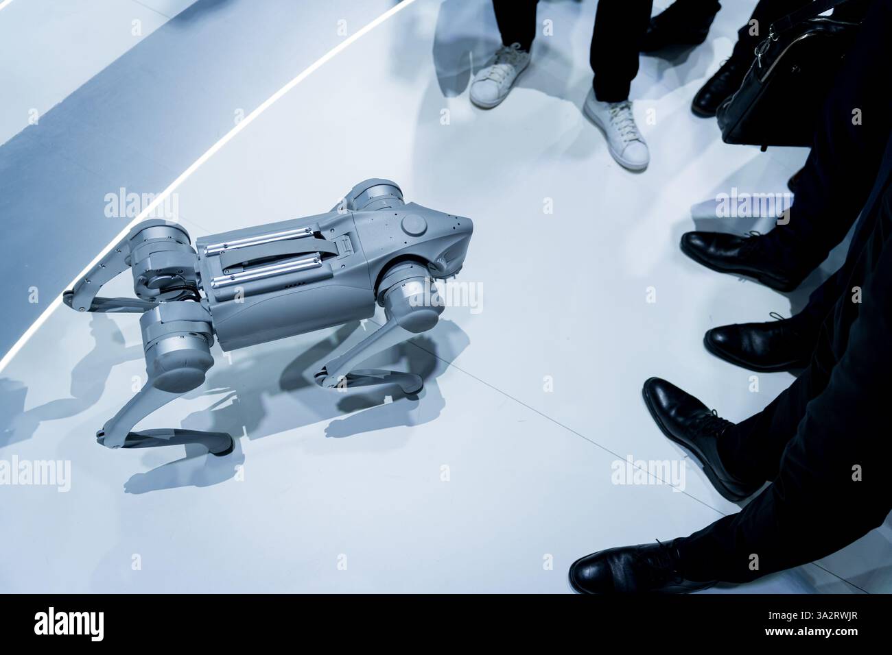 A robot dog walking and playing around people at a technology trade ...