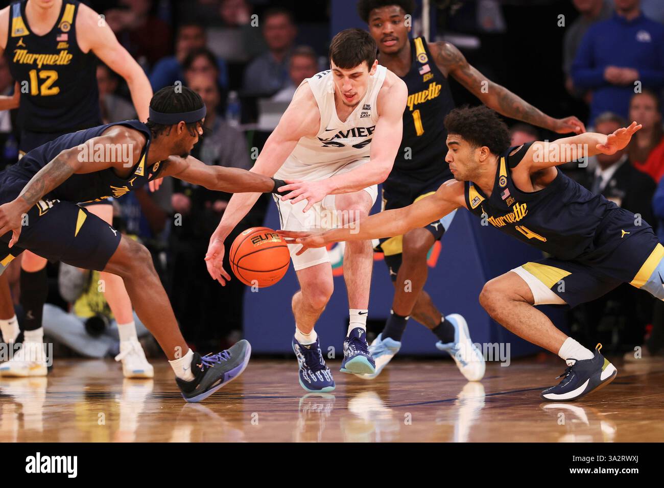 Marquette guards Chase Ross, left, and Stevie Mitchell, right, reach in ...