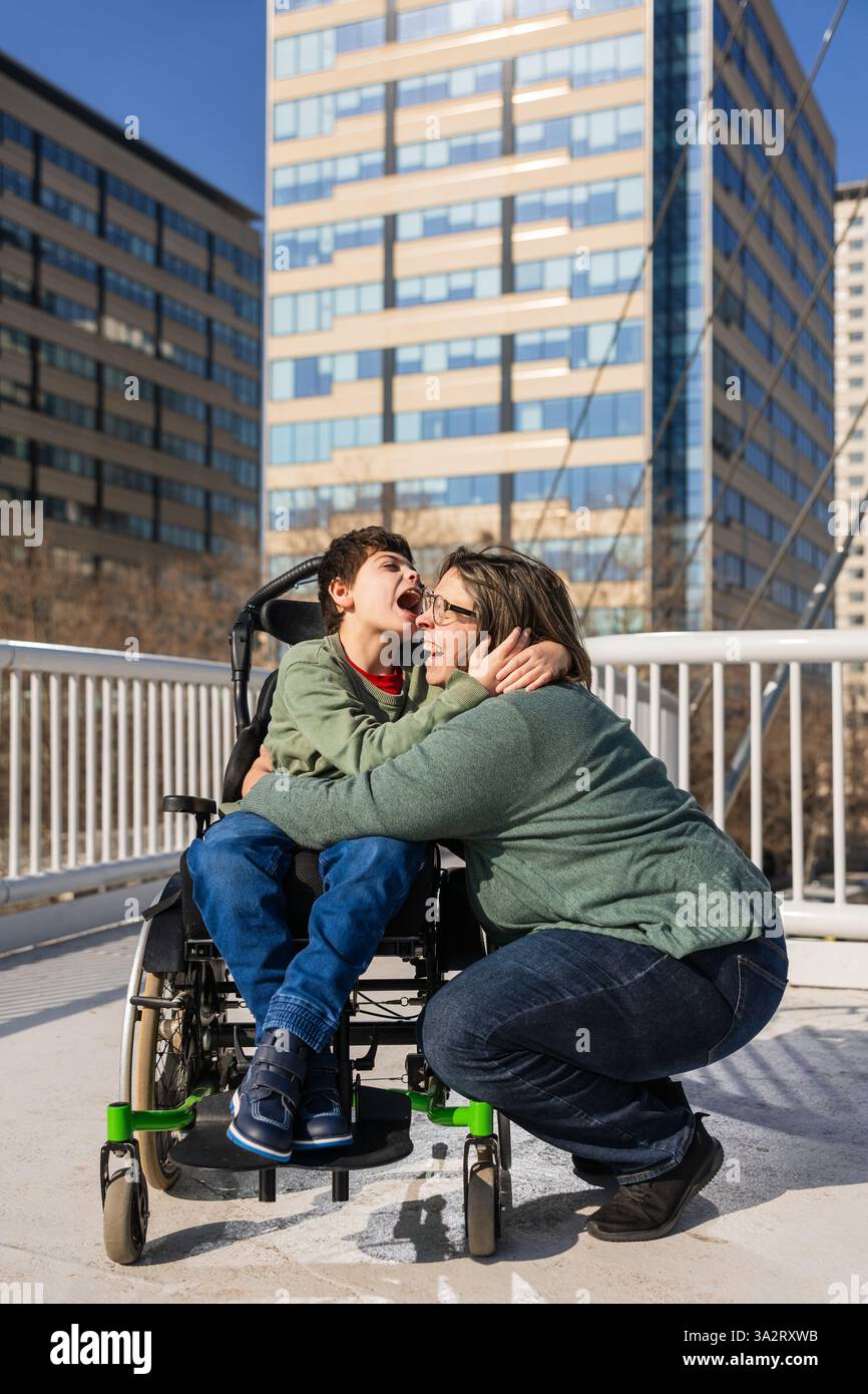 Mother hugging her son with disability with cerebral palsy in a ...