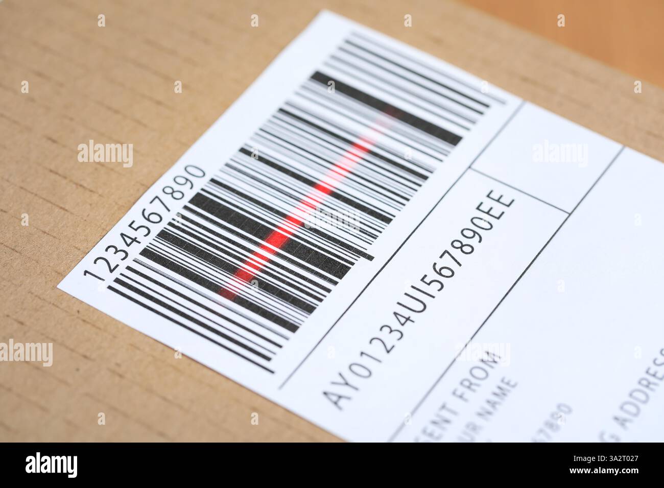 Parcel with label, closeup. Red laser light on barcode for scanning ...