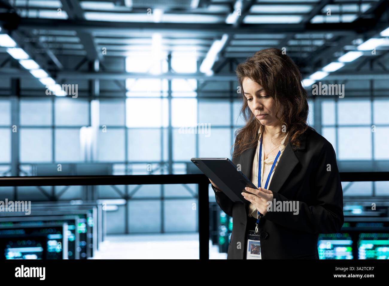 System administrator in data center uses automation tools on tablet, running predictive ...