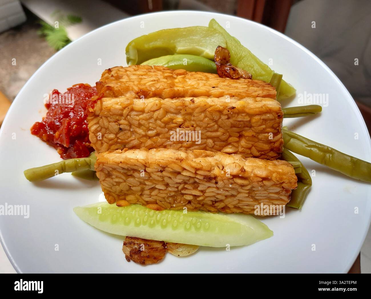 Indonesian food Tempe Goreng or fried tempeh with vegetables and red ...