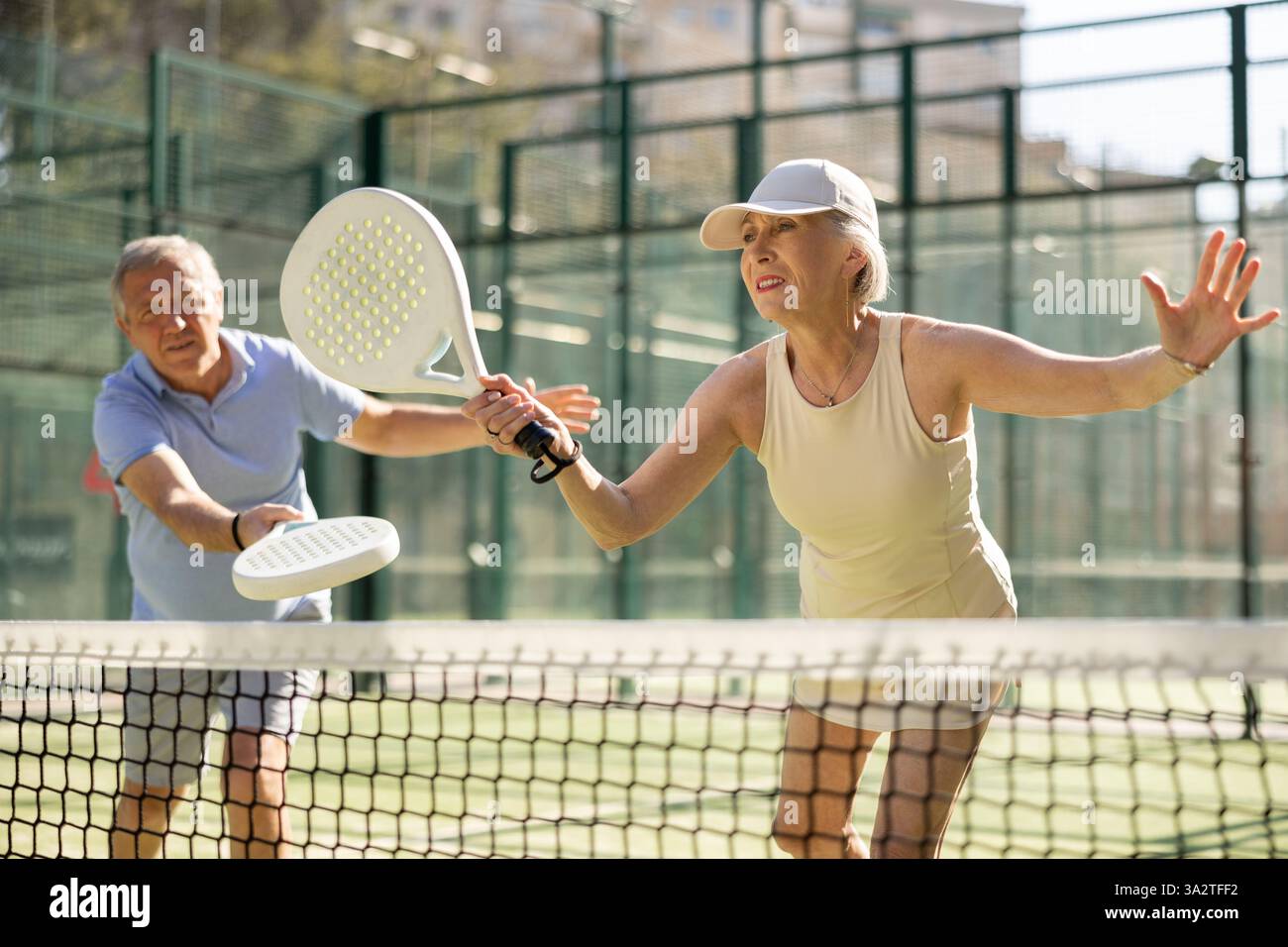 Old man and woman playing Padel Tennis in open-air tennis court Stock ...