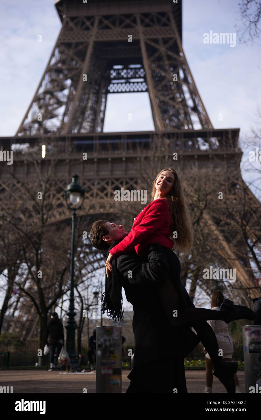 A loving couple shares a romantic moment in front of the Eiffel Tower ...