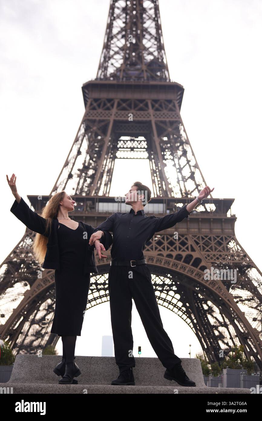 A stylish couple performs an elegant dance pose in front of the Eiffel ...