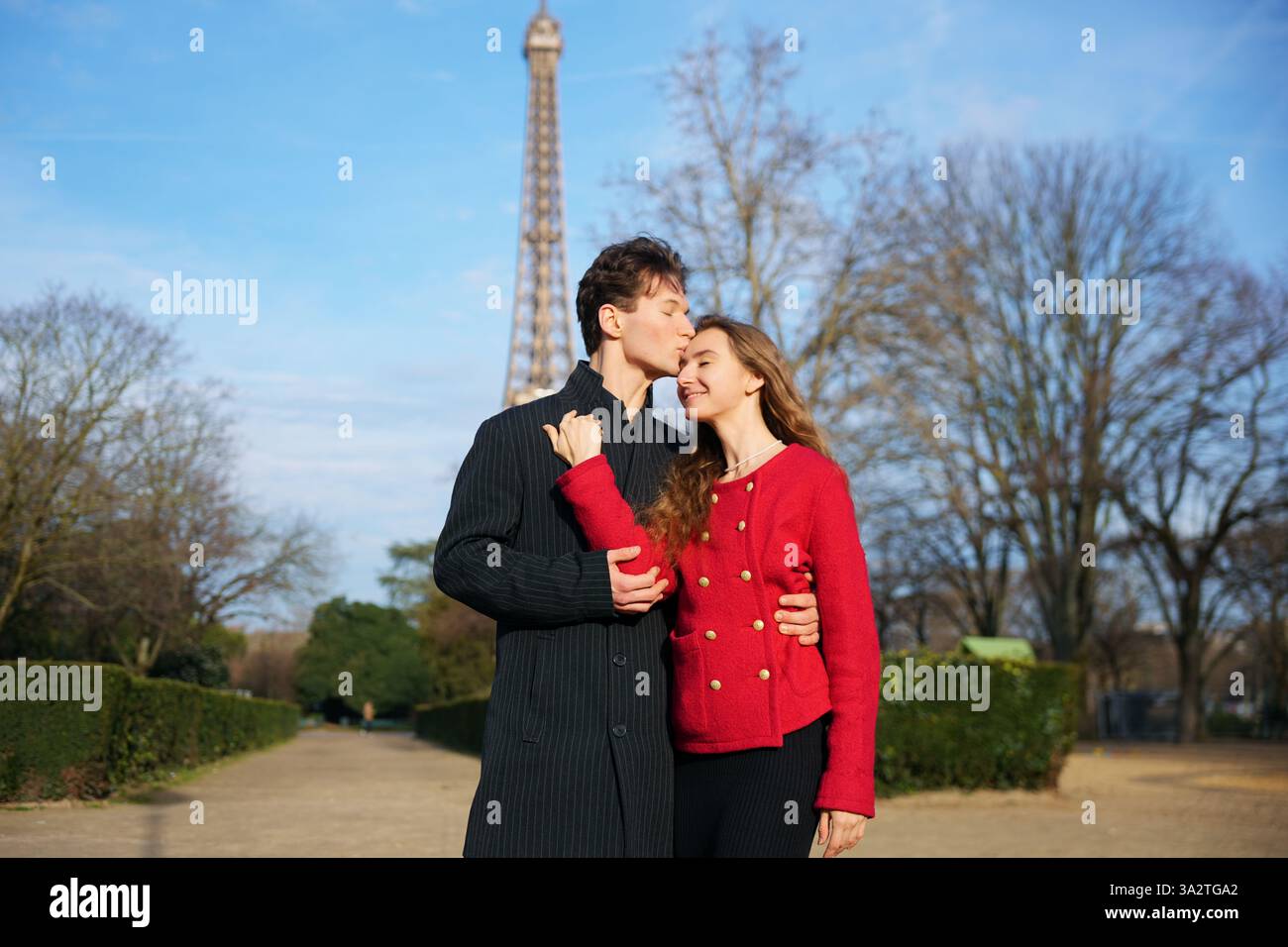 A loving couple shares a romantic moment near the Eiffel Tower in Paris ...