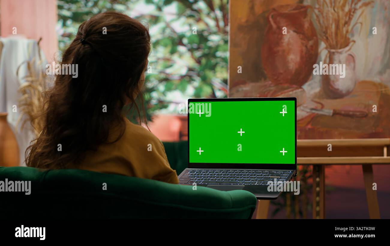 Female artist using green screen sitting in her art and craft atelier ...